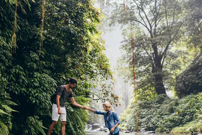 Man Helping Woman Crossing Stream Photo (122910) - YouWorkForThem