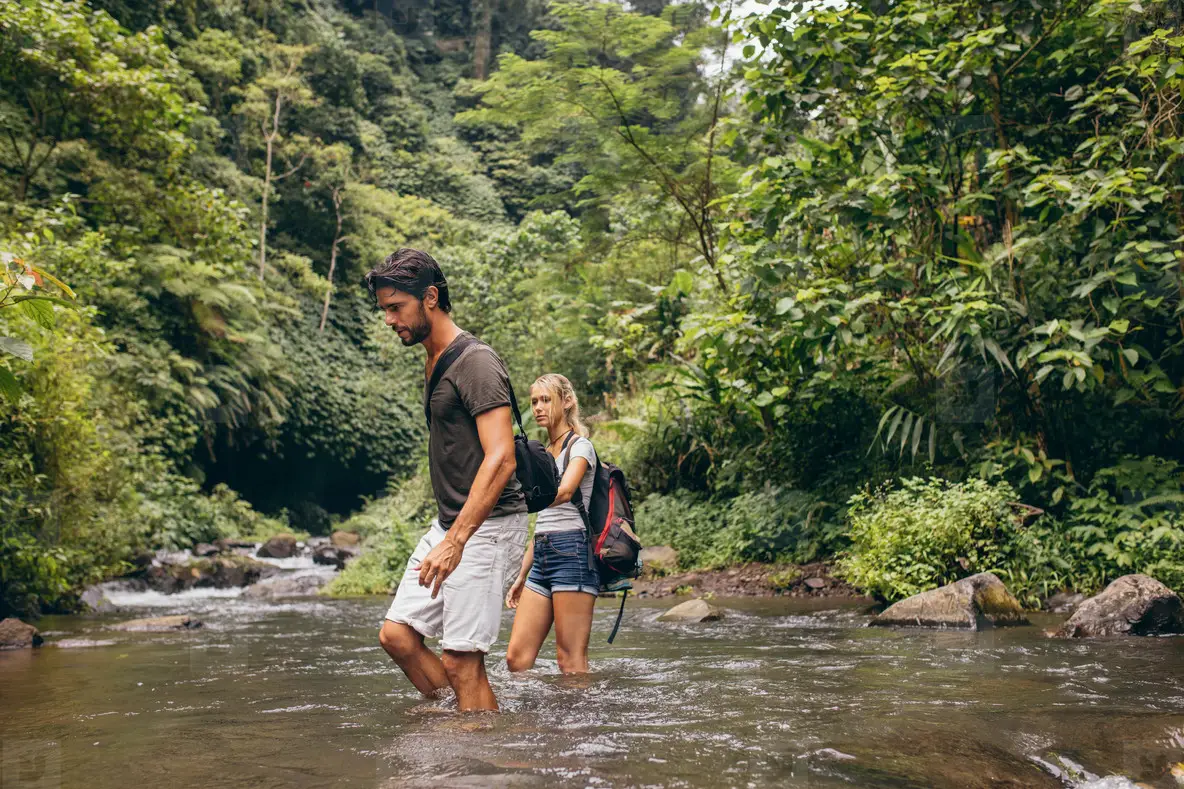Couple Crossing Mountain Stream Photo (122971) - YouWorkForThem