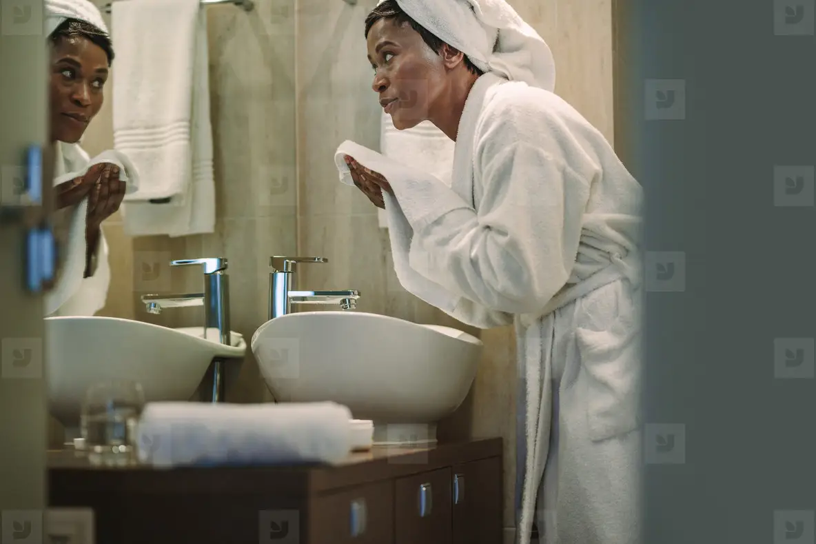 African Female Cleaning Her Face With Towel In Bathroom Photo (166014 ...