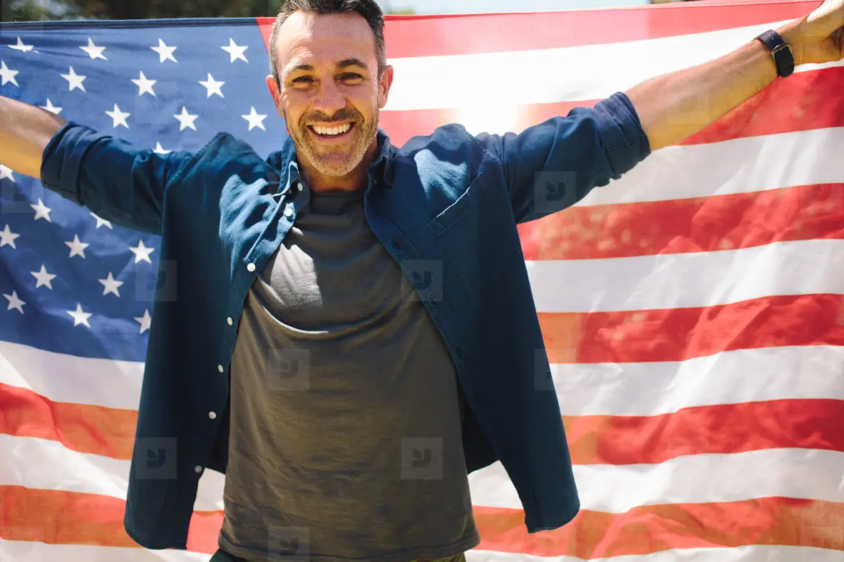 Happy Man Standing Outdoors Holding American Flag Photo (169167 ...