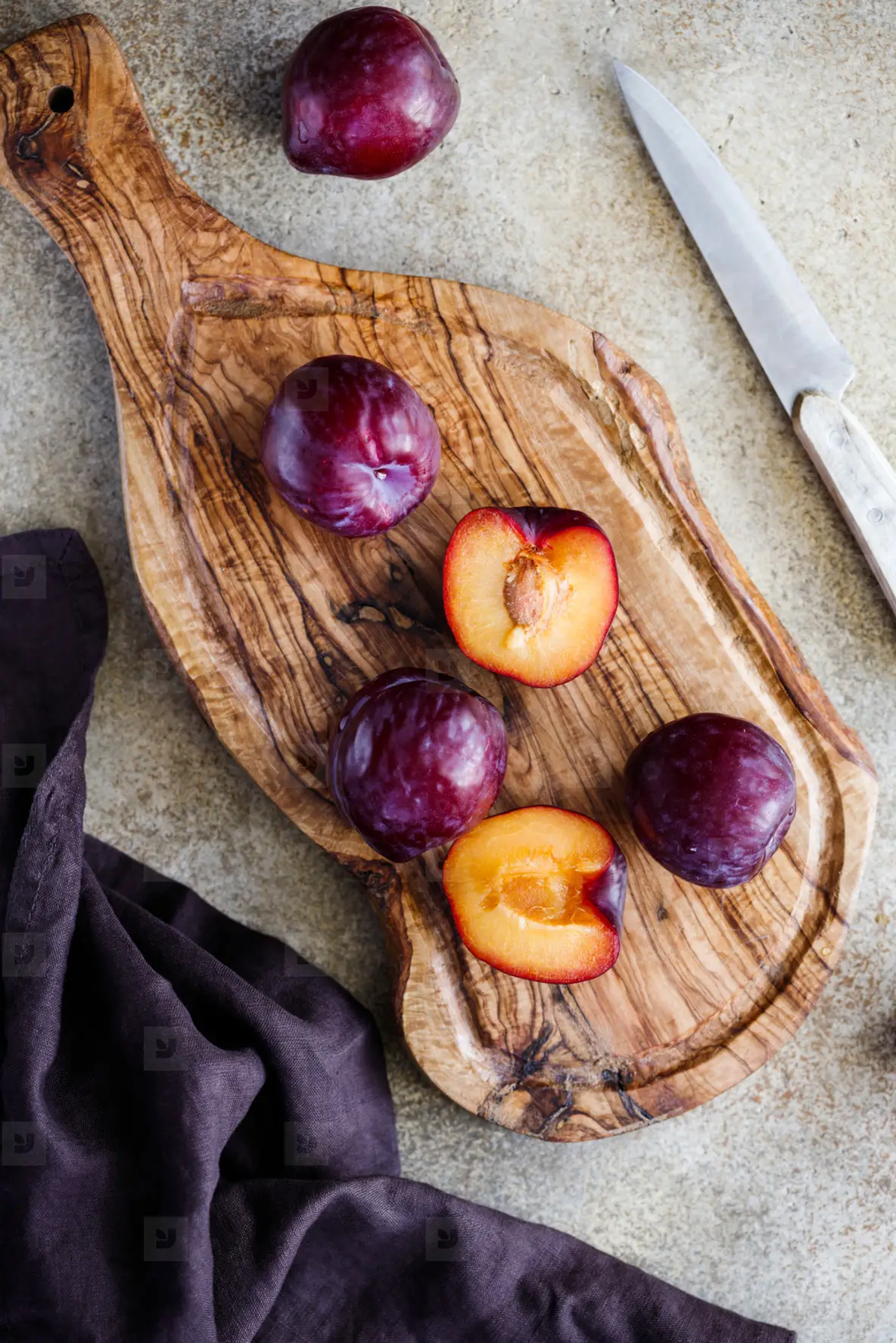 High Angle View Of Fresh Purple Plum On A Textured Wooden Cutting Board ...