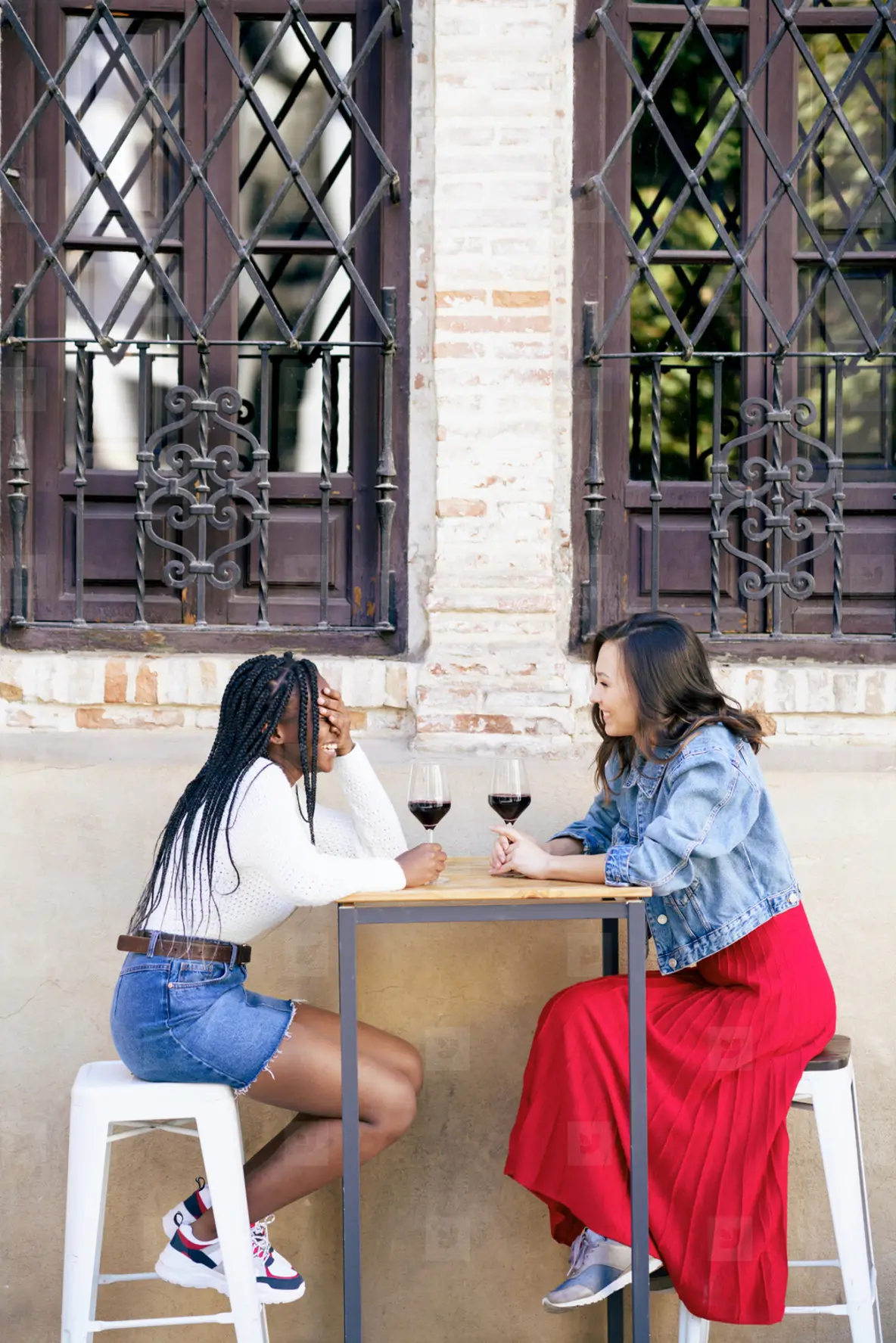 Two Women Drinking Red Wine Sitting At A Table Outside A Bar Photo ...