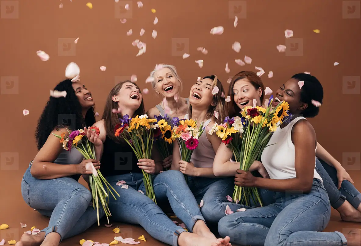 Group Of Diverse Women With Bouquets Having Fun Under Falling Petals ...