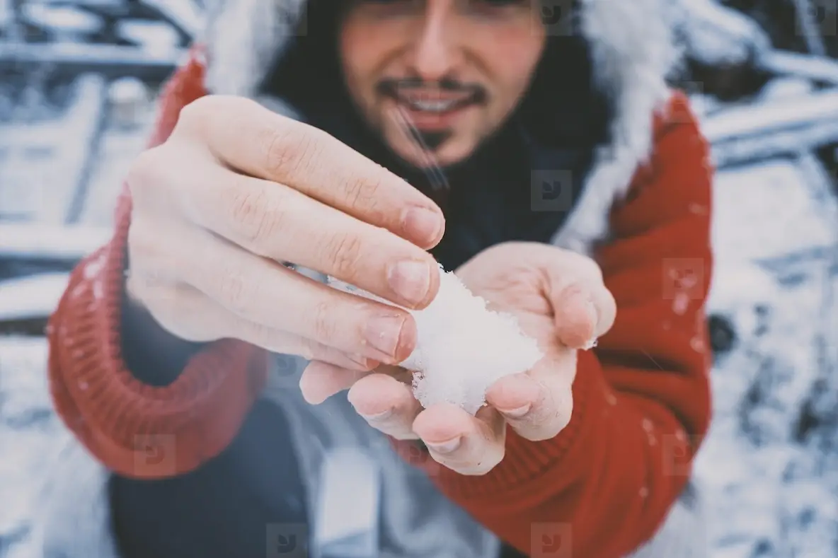 Young Man Enjoying A Snowy Day Wearing A Fur Hat And A Red Hoodi Photo ...