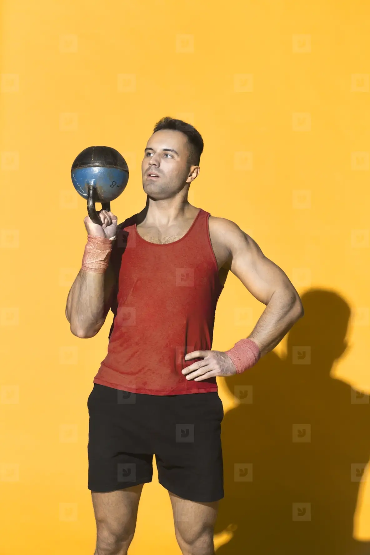 Strong Athletic Man Lifting Kettle Bell Against Yellow Background Photo ...