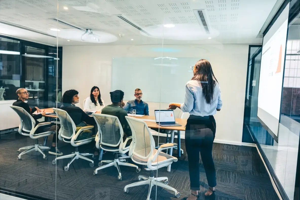 Businesswoman Giving A Presentation To Her Colleagues In An Office ...