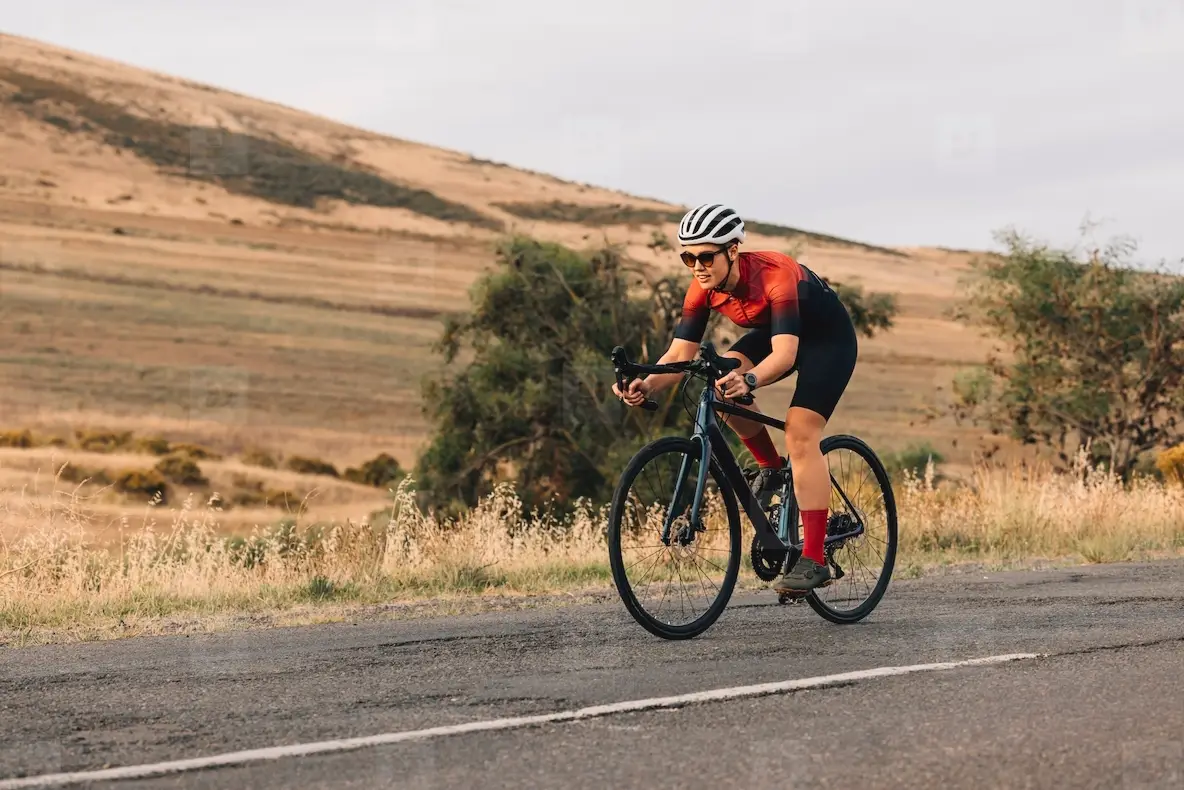 Athletic Woman Taking A Bicycle Ride On The Empty Countryside Road ...