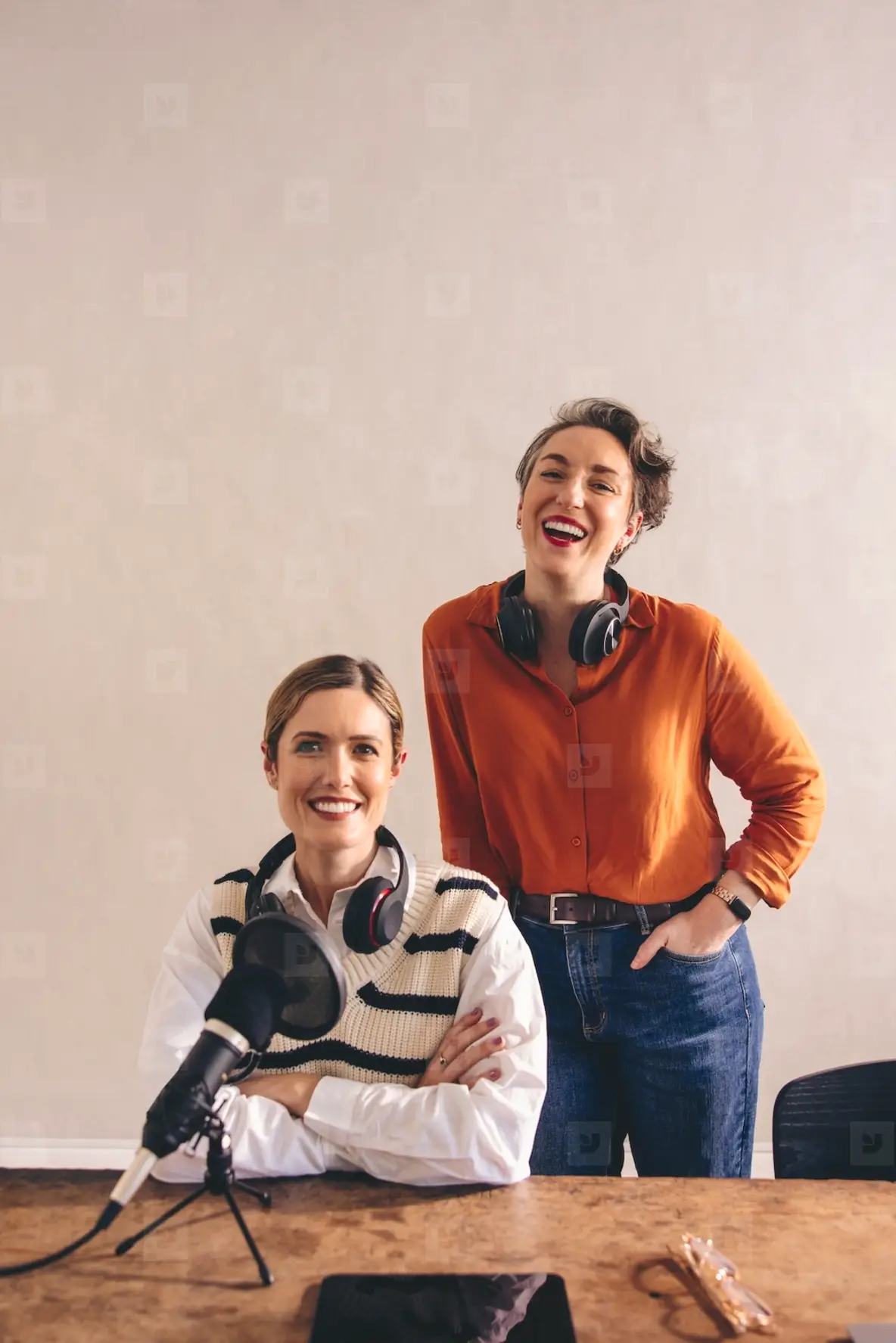 Two Female Podcasters Smiling At The Camera In A Studio Photo (263429 ...