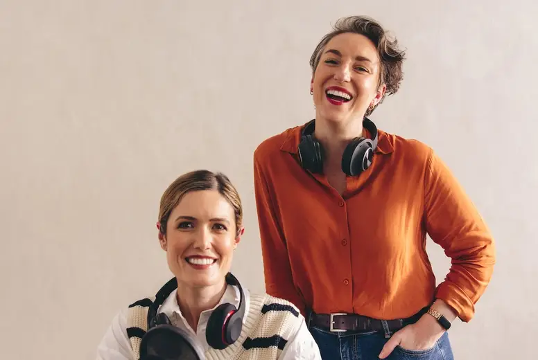 Two Female Podcasters Smiling At The Camera In A Studio Photo (263429 ...