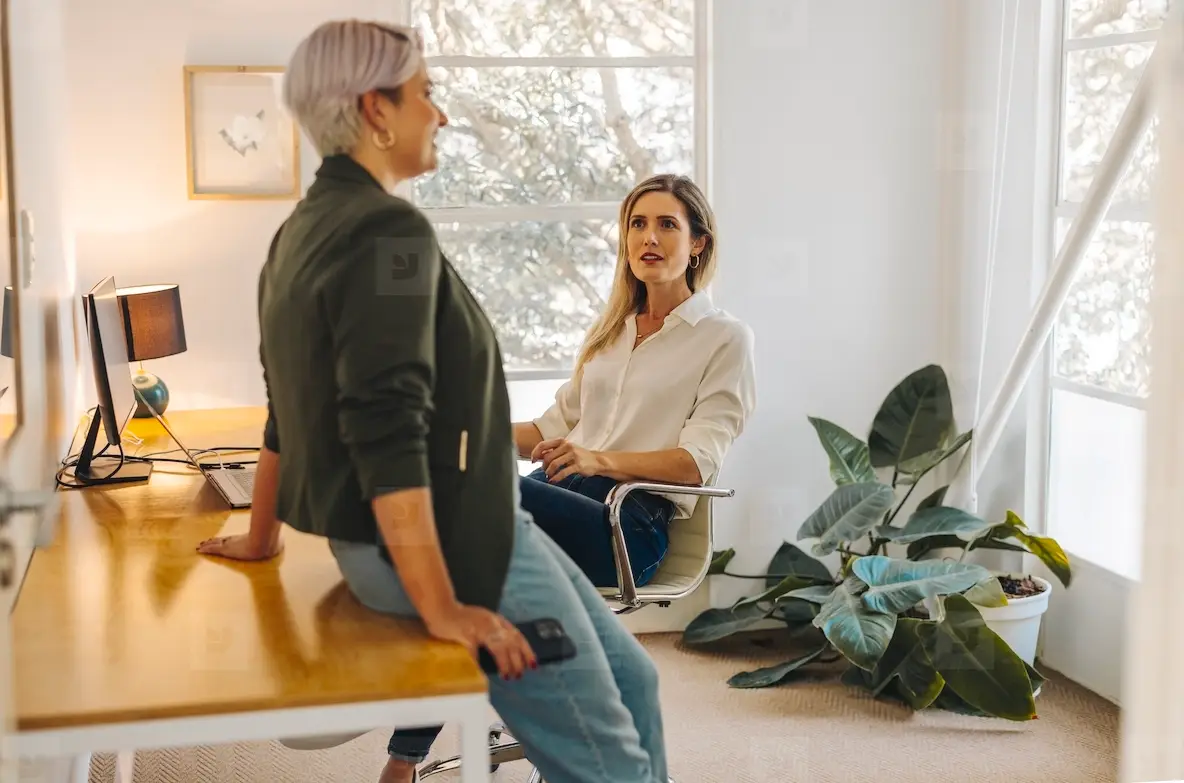 Two Young Businesswomen Having A Discussion In An Office Photo (264582 ...