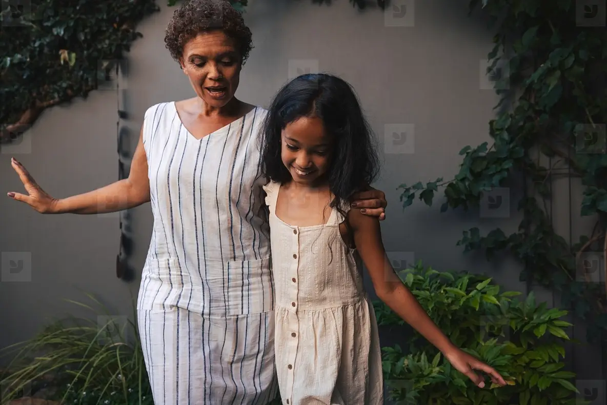 Happy Grandma And Granddaughter Dancing Together In Backyard Photo ...