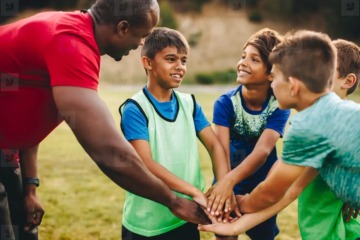 Sports Trainer Having A Huddle With His Team In A School Field Photo ...
