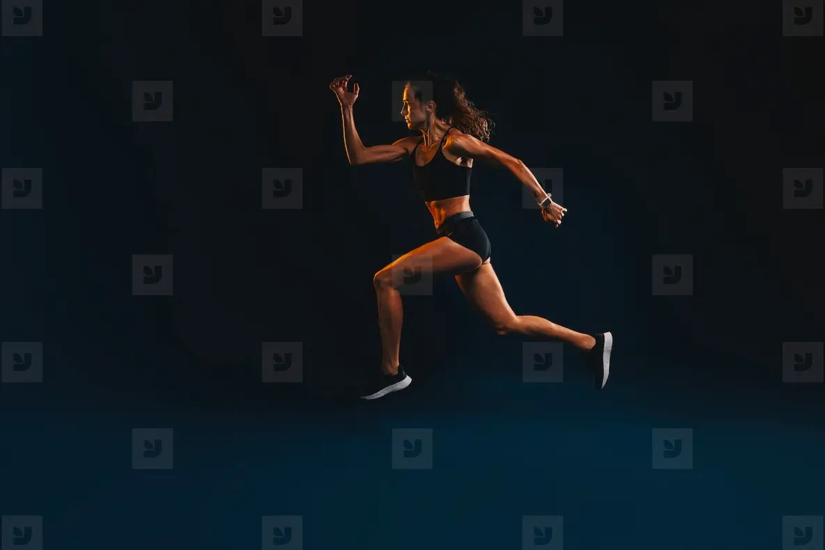 Sprinter Against A Black Background. Muscular Female Running And ...