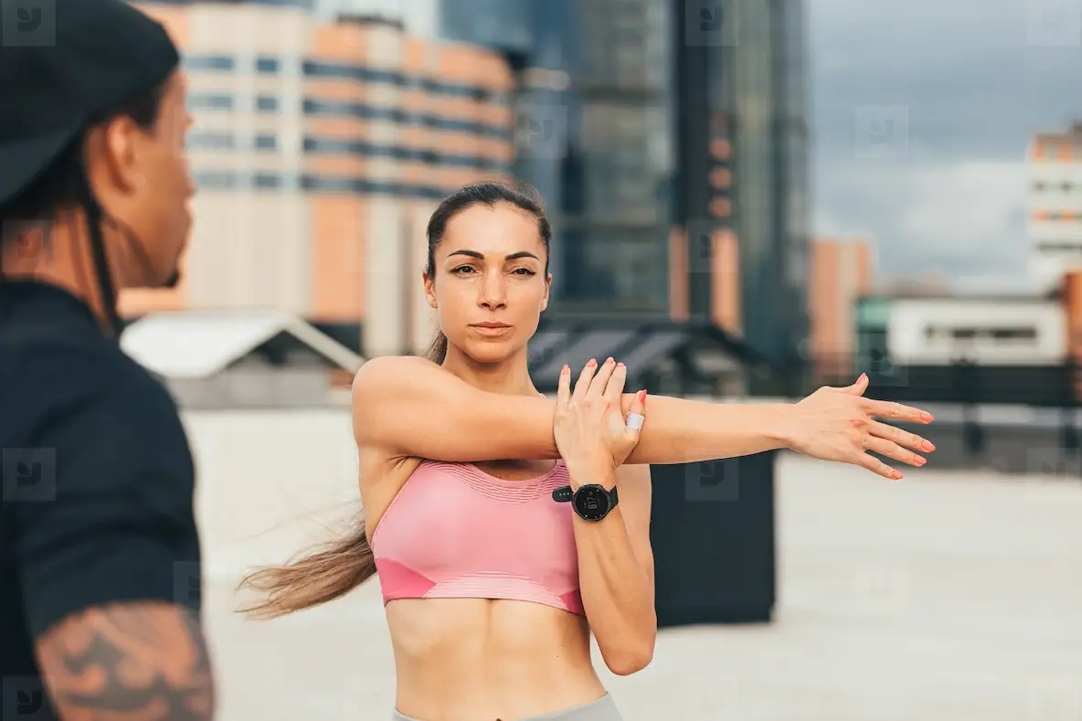 Young Female Stretching Her Arm Before Training On Rooftop Photo ...