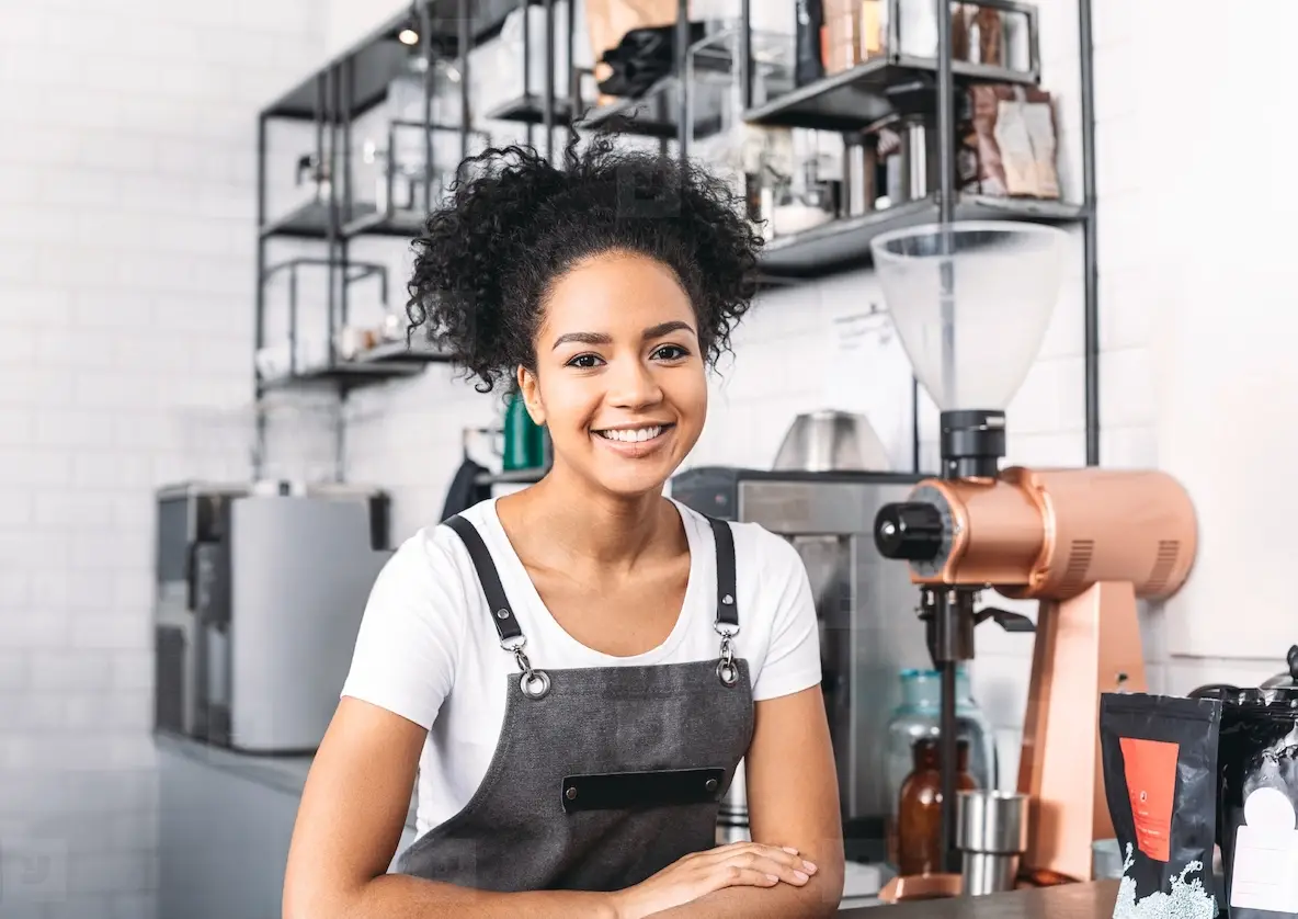 Portrait Of A Smiling Barista With Curly Hair. Young Female Working As ...