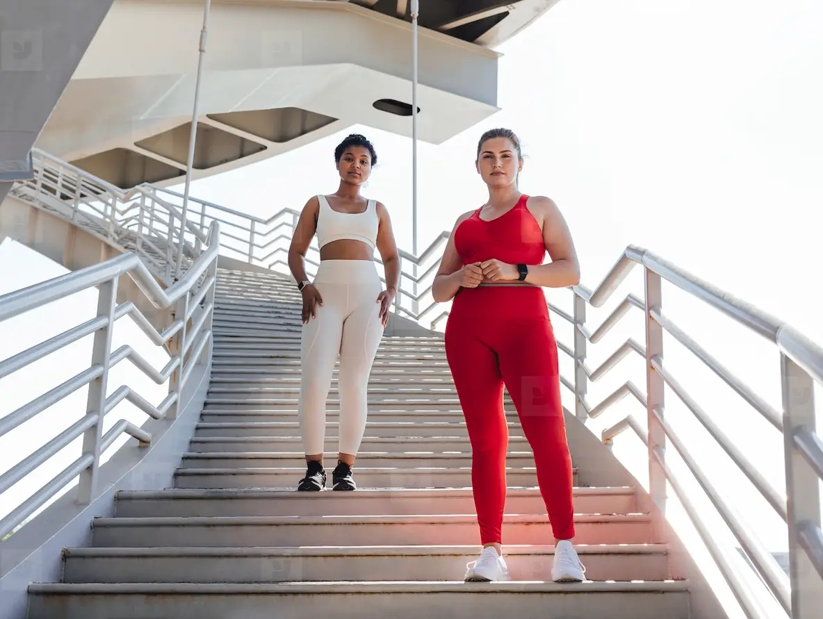 Two Females In Fitness Attire With Different Colors Looking At Camera ...