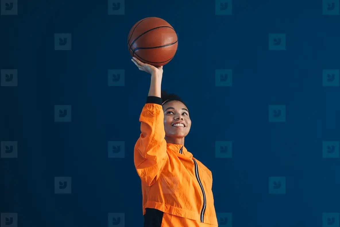 Cheerful Female With Curly Hair Holding A Basketball Over Blue Backdrop ...