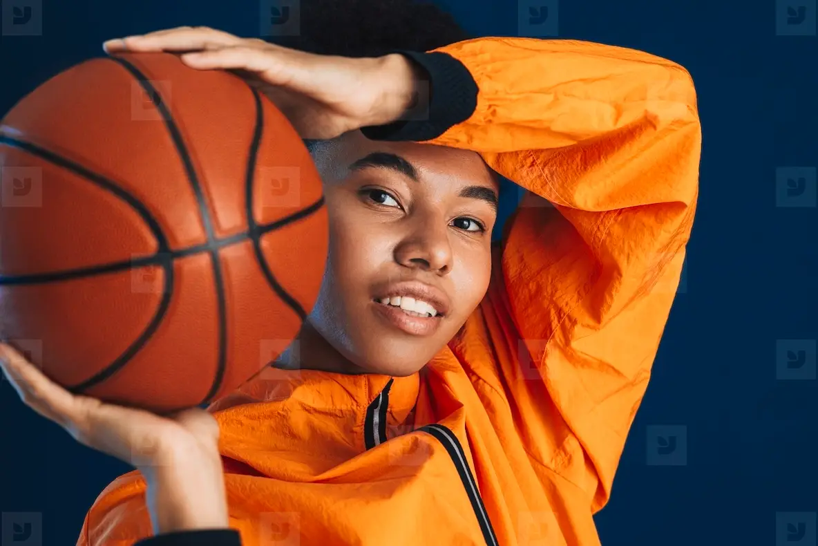Close-up Of A Young Woman In Orange Sportswear Holding Basketball ...