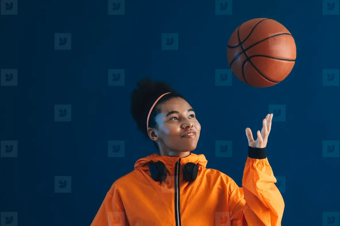 Cheerful Female In Orange Fitness Attire Throw A Basketball Over Blue ...