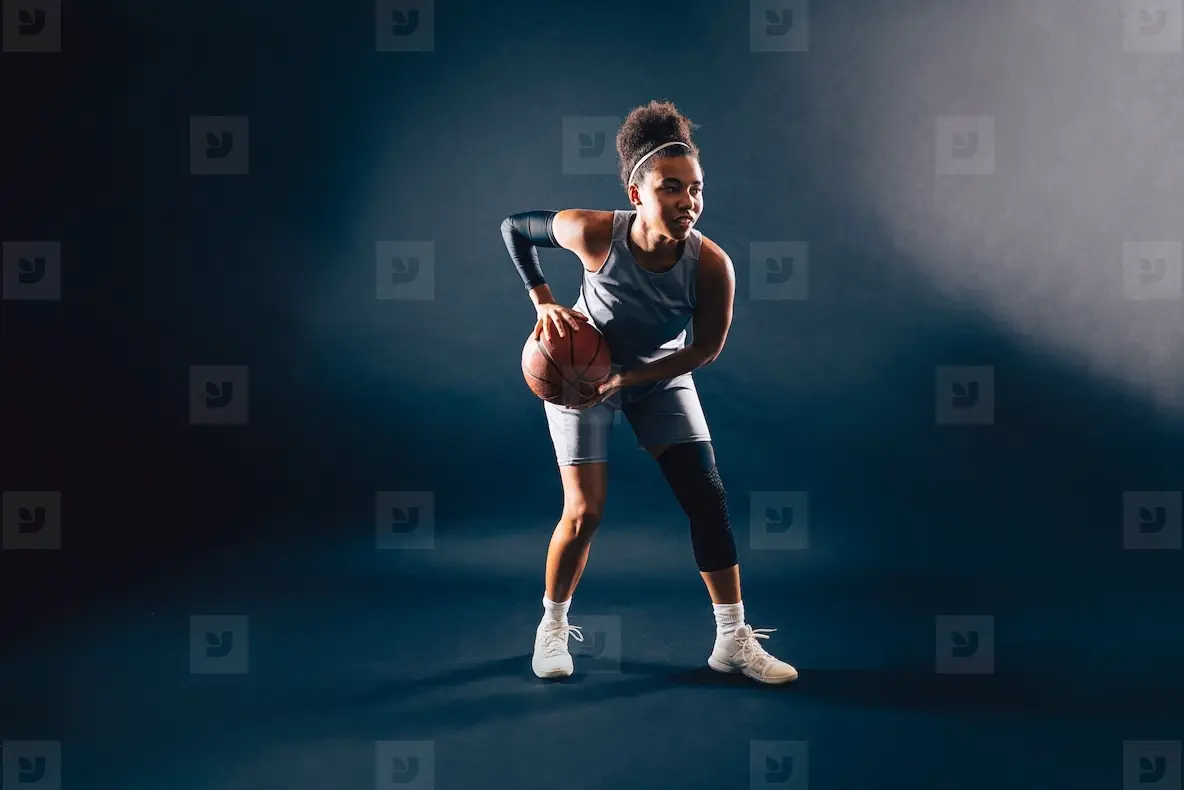 Professional Female Basketball Player In Uniform With Ball Over Dark ...