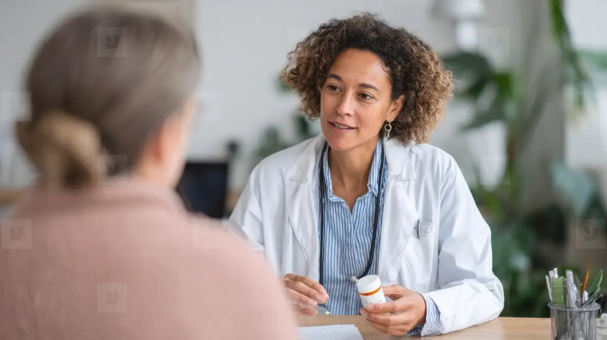 Doctor Discussing Medication Side Effects With Patient In Clinical ...